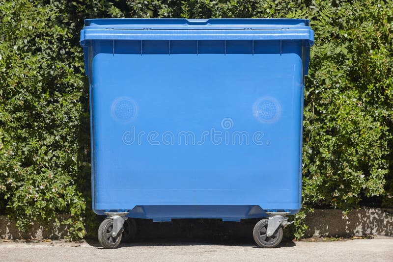 Blue Recycling Container for Paper with Green Bush Background Stock ...