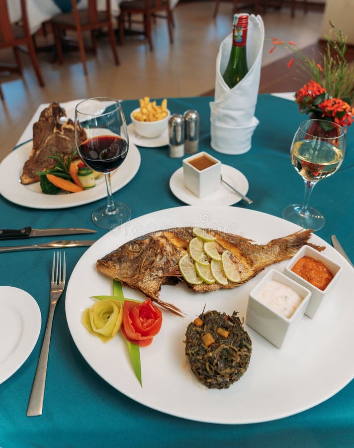 Blue Restaurant Dinner Table with Plates of Steak, Fish, and Wine Stock ...