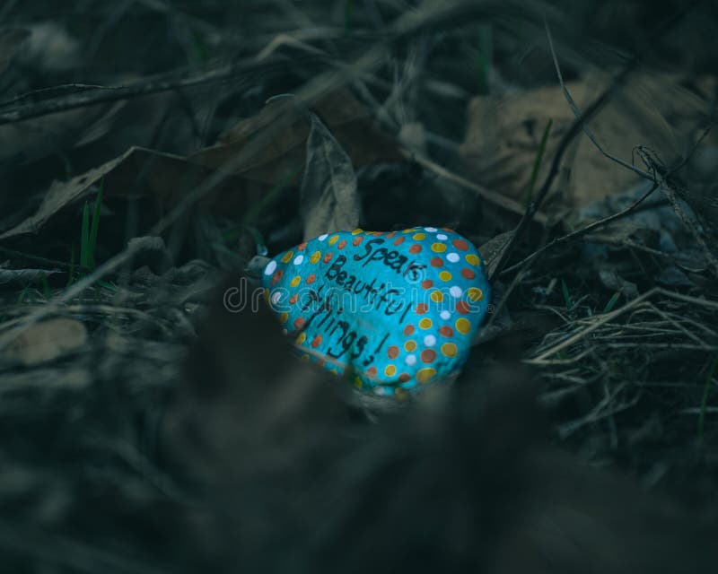 A Blue Rock with the Words Speak Beautiful Things Stock Image - Image ...