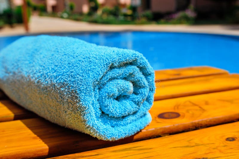 Blue Rolled-up Towel Lying on a Lounger Near the Pool Stock Photo ...