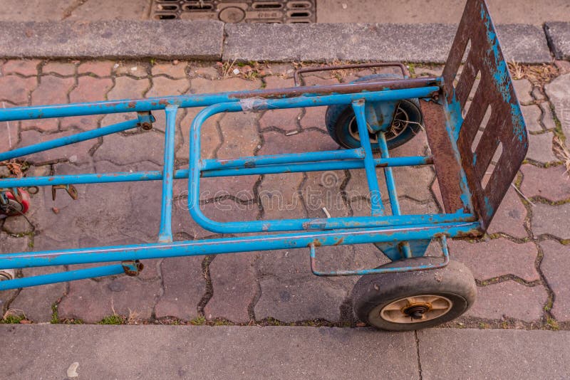 Blue Rusty Dolly on Sidewalk Stock Image - Image of laying, rust: 168122653