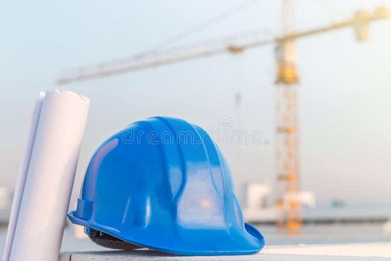 The Blue Safety Helmet and the Blueprint at Construction Site with ...