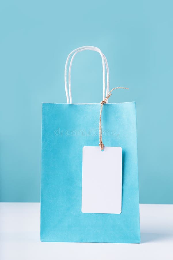 Blue Shopping Bag with a Blank White Tag on White Table Stock Photo ...