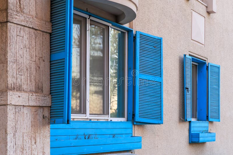 Blue Shutters on Beige Wall of European Building with Open Windows ...