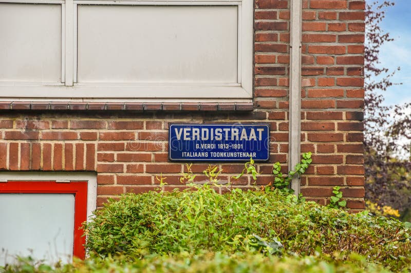 A Blue Sign on the Side of a Brick Building Editorial Photo - Image of ...