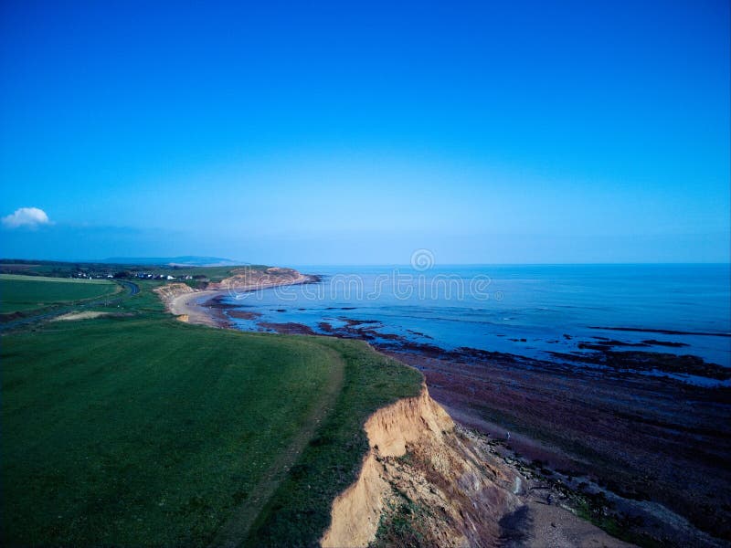Blue Water Ocean Beach Muddy Cliffside Stock Image - Image of trees ...