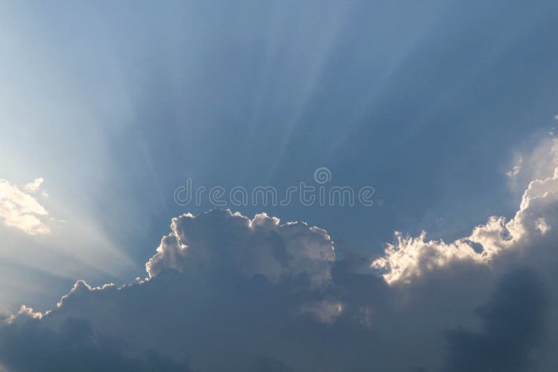 In the Blue Sky the Rays of the Sun Come Out from Behind the Clouds ...