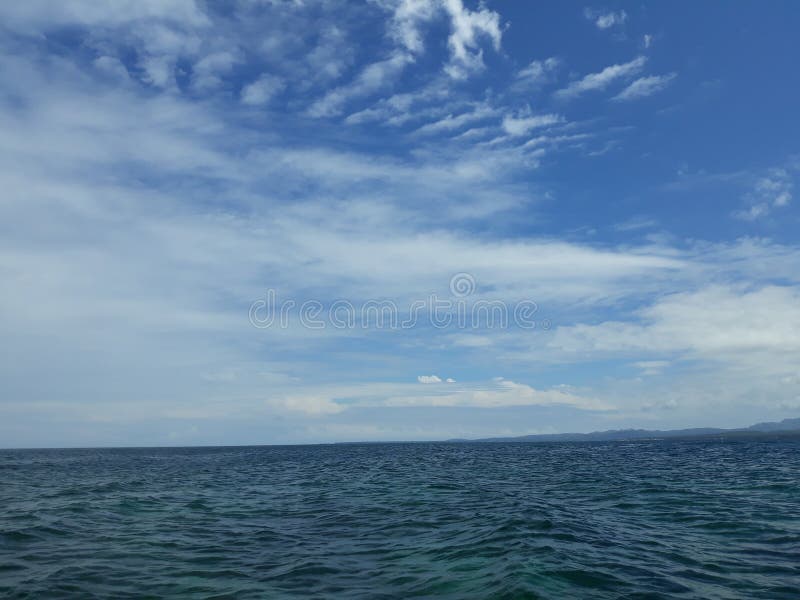 The Blue Sky with White Clouds Above the Vast Ocean and Waving Stock ...