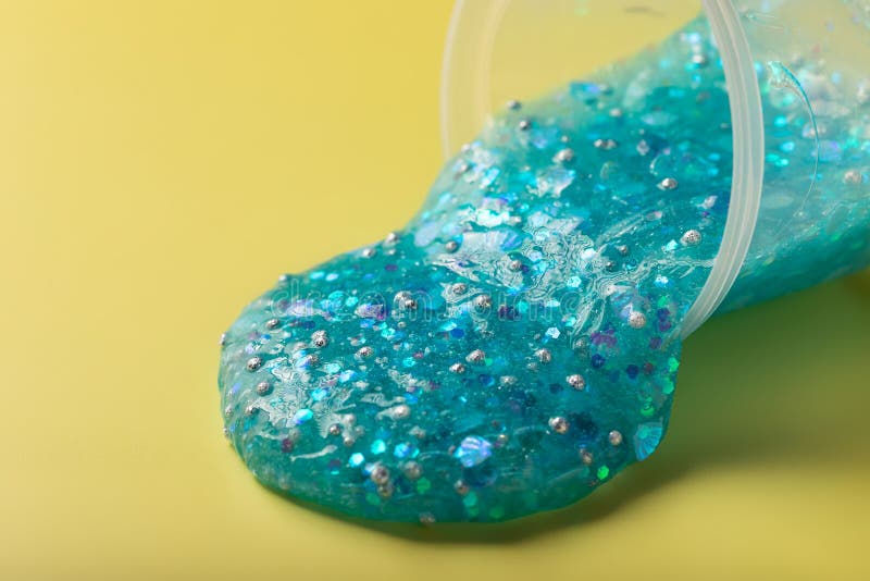 Blue Slime Flows Out of Plastic Container on Yellow Background Stock ...