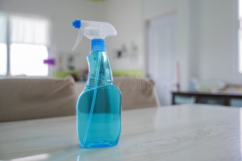 Blue Spray Bottle with Clear Liquid on White Tabletop, in Focus with ...