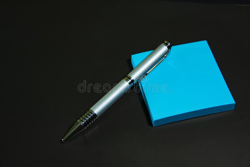 Blue Stickers and a Silver Ballpoint Pen Lie on a Black Matte Surface ...