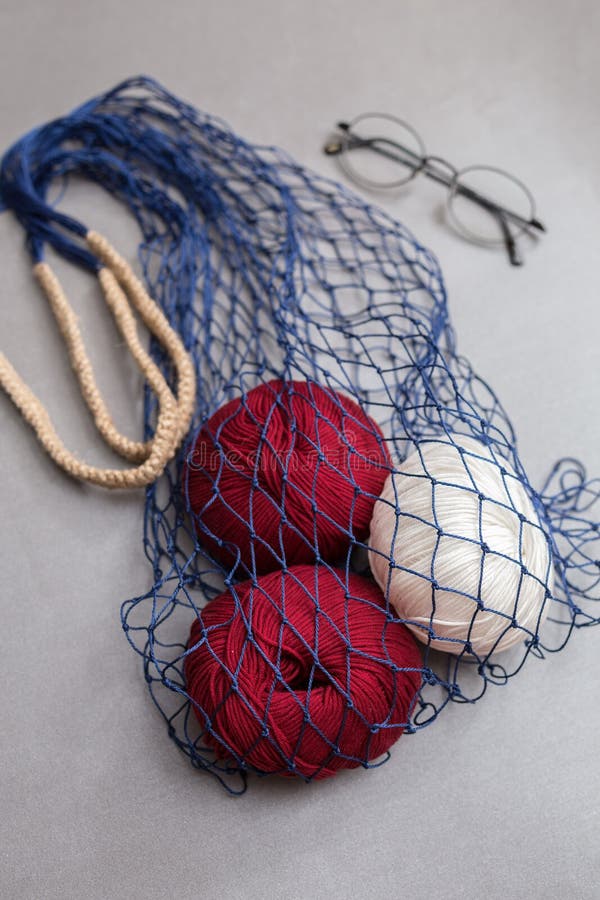 Blue String Bag with Various Knitting Yarn and Black Modern Glasses ...