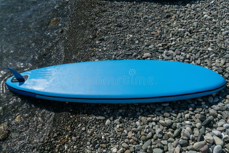 Blue SUP on a Pebble Beach by the Sea. Stock Image - Image of ...