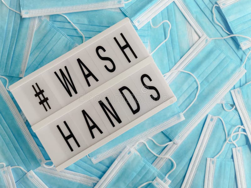 Blue Surgical Face Masks with a White Light Box Stating # Wash Hands ...