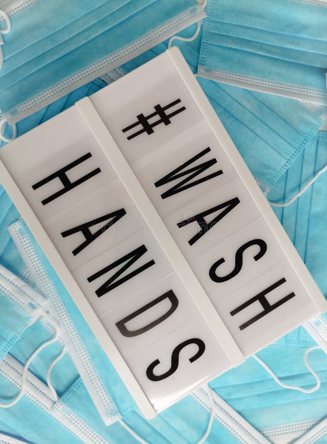 Blue Surgical Face Masks with a White Light Box Stating # Wash Hands ...