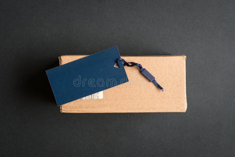 Blue Tag on Top of Cardboard Package Stock Photo - Image of blue, card ...