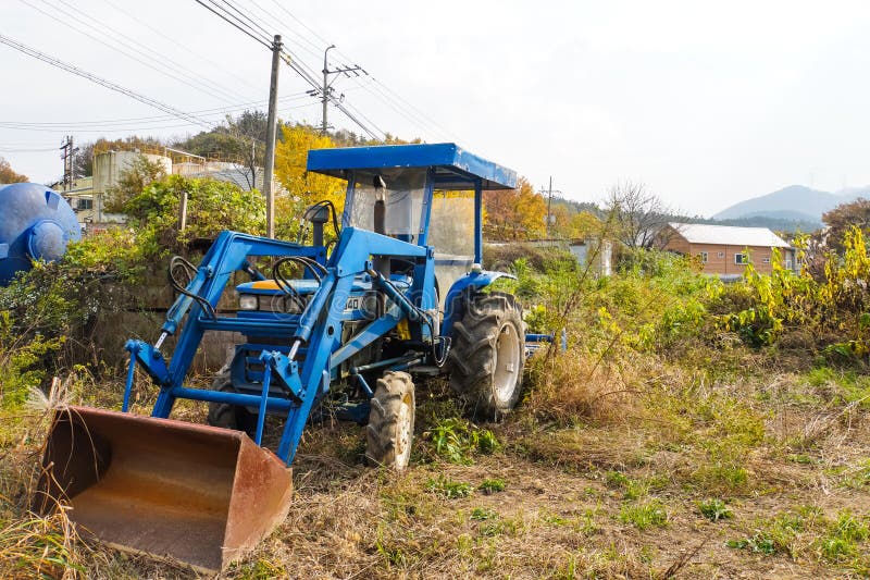 Blue Tractor with Front Scoop and Backhoe. Farm Tractor Stock Photo ...