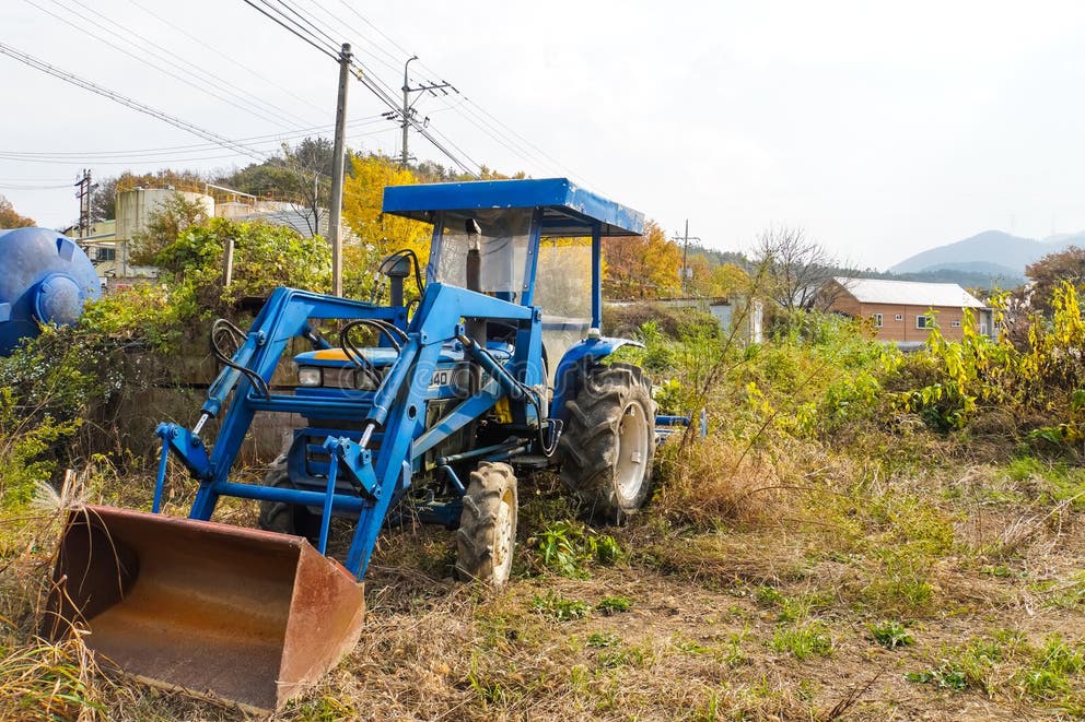 Blue Tractor with Front Scoop and Backhoe. Farm Tractor Stock Photo ...