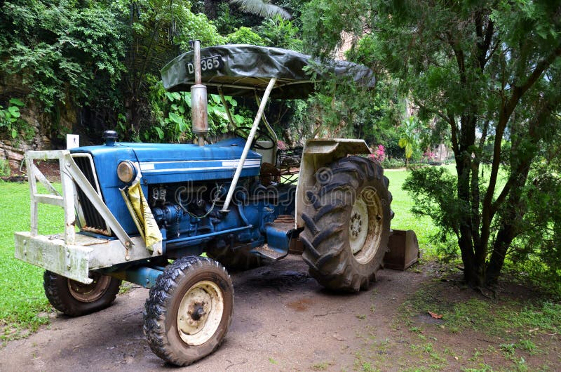 Blue tractor in the garden stock photo. Image of equipment - 64321008