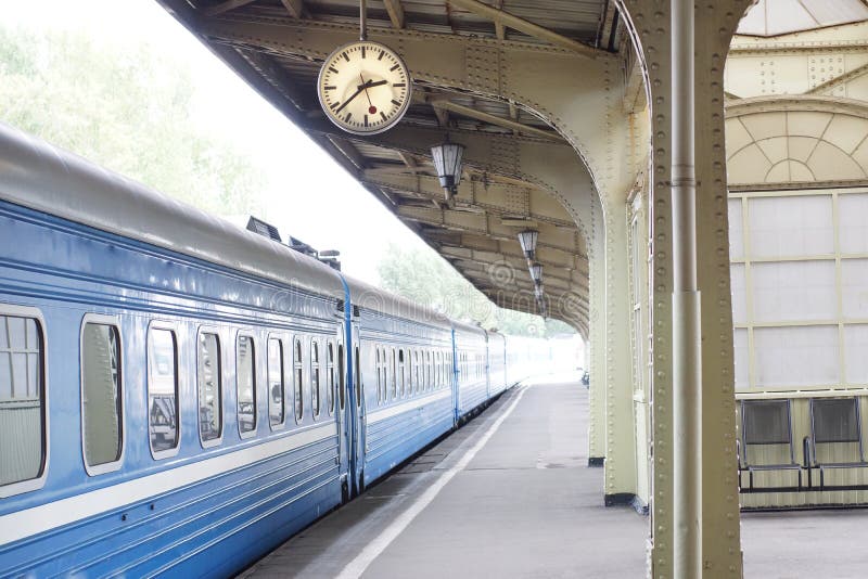 Blue Train Stands on the Platform at the Train Station with a Clock ...