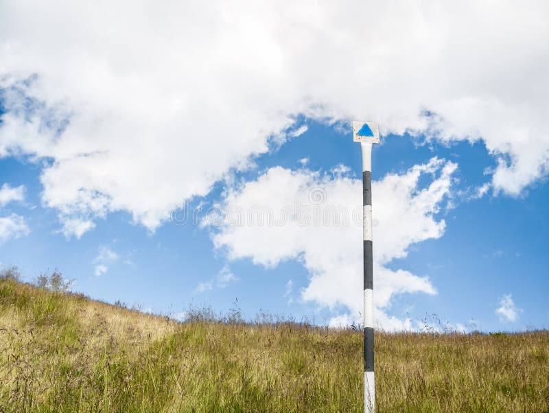 Blue Triangle Hiking Trail Mark on a Pole with the Blue Sky and White ...