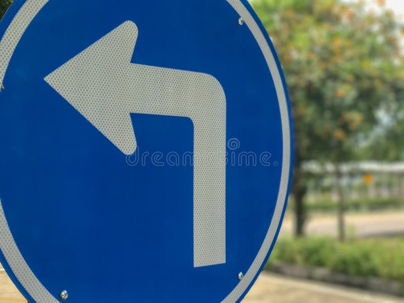 Blue Turn Left Sign on Pole Stock Image - Image of park, directional ...