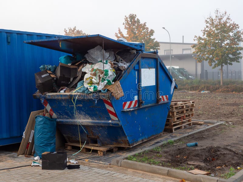 Blue Waste Container Filled with Construction Site Waste Stands on a ...
