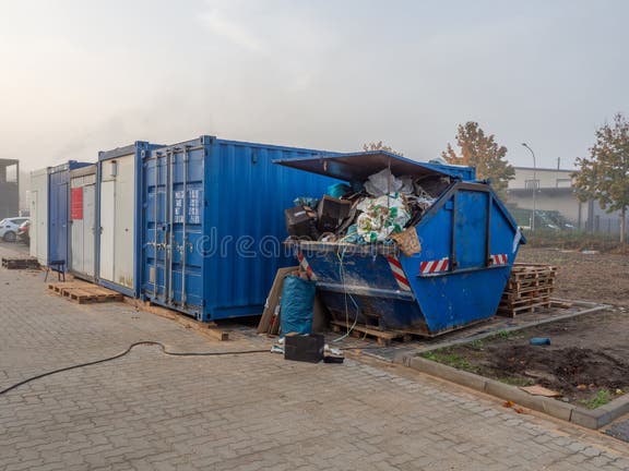 Blue Waste Container Filled with Construction Site Waste Stands on a ...