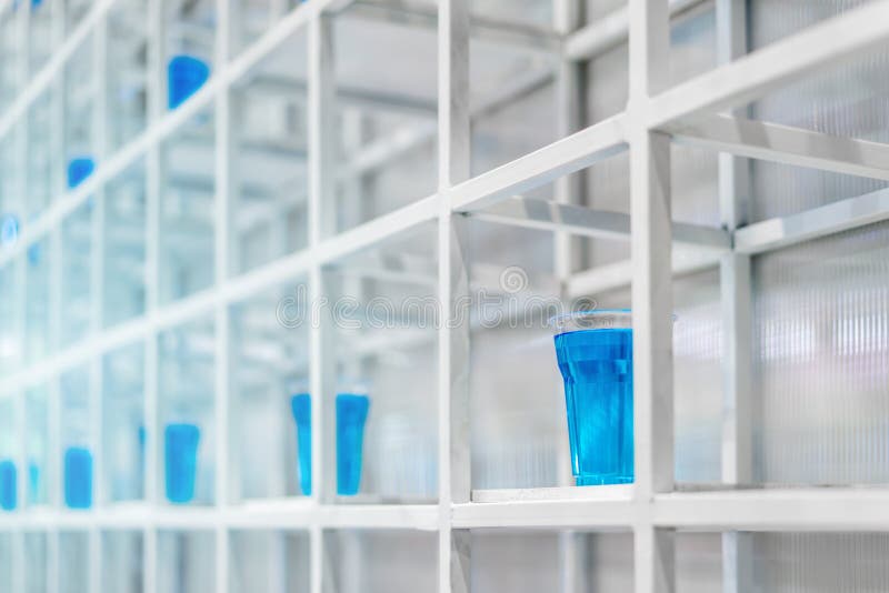 Blue Water Inside Clear Plastic Cup on White Metal Shelf Structure for ...