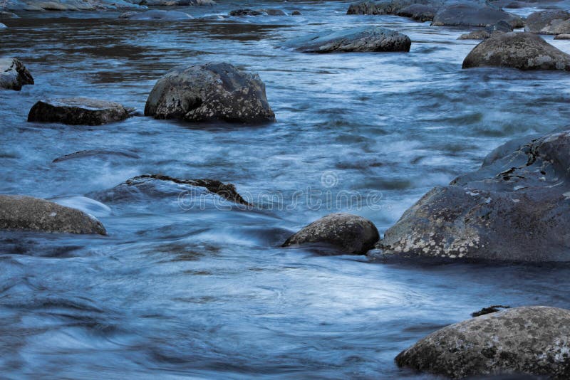Blue Waters Around Rocks, with Reflections from the Sky Stock Image ...
