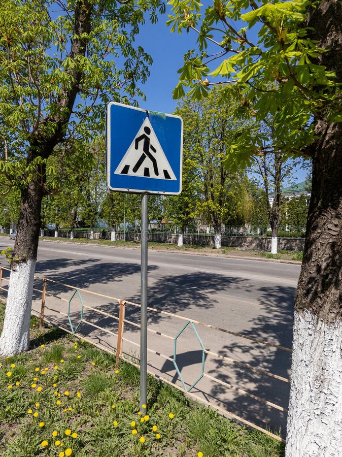 A Blue and White Pedestrian Crossing Sign on the Side of a Road Stock ...