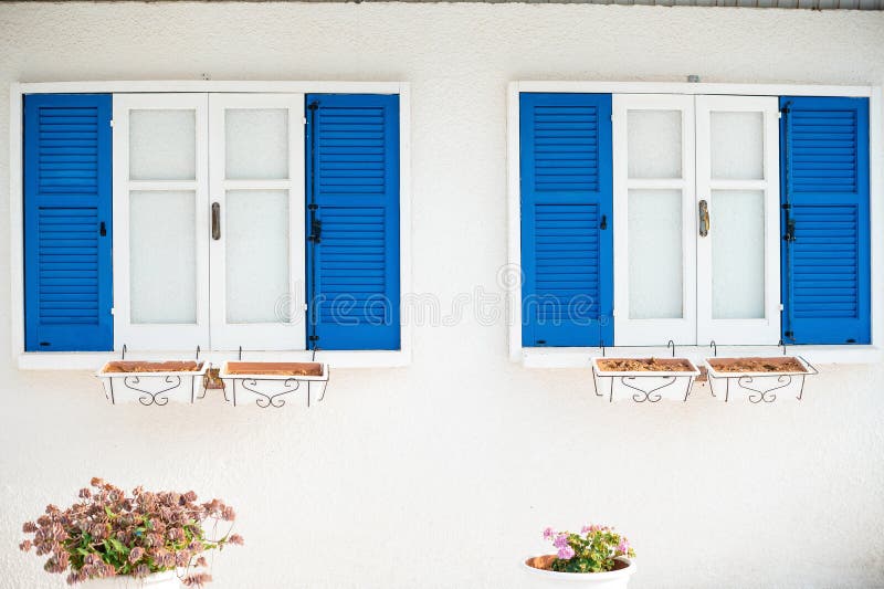 Blue and White Shuttered Windows with Flower Pots Stock Image - Image ...