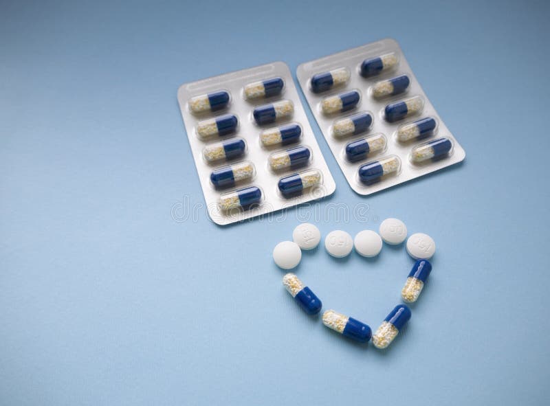 Blue and White with Yellow Medical Pills and Tablets in Heart Shape on ...