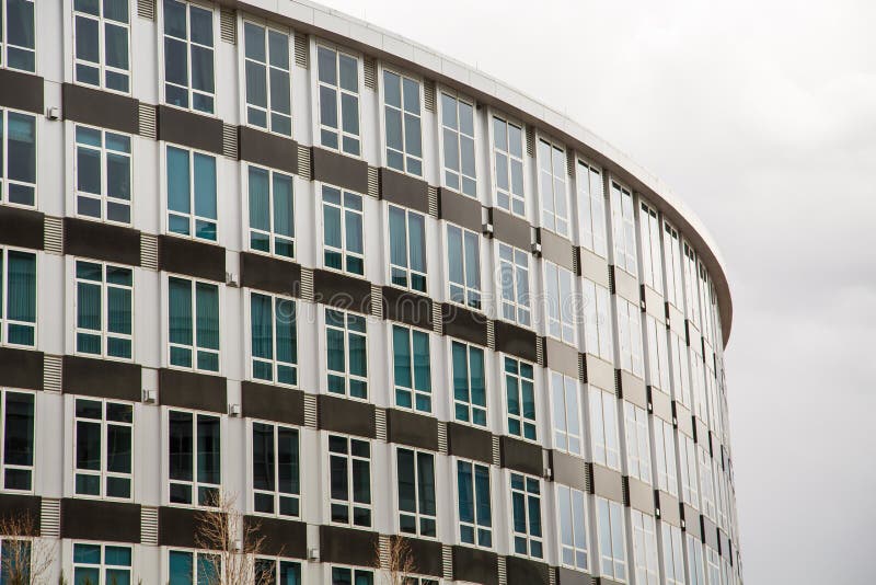 Blue Windows on Brown and Silver Curved Building Stock Photo - Image of ...
