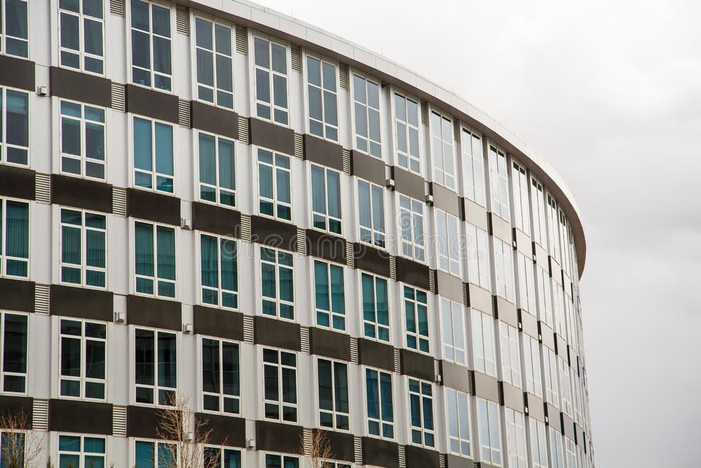 Blue Windows on Brown and Silver Curved Building Stock Photo - Image of ...