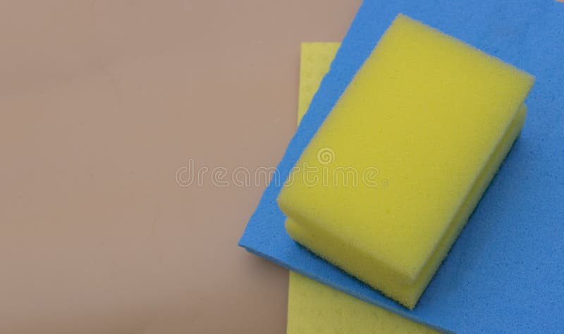 A Blue and Yellow Sponge is Placed on Top of the Table, Which Has Two ...