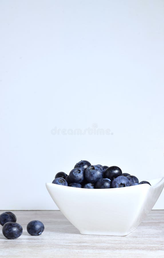 Blueberries in Porcelain Bowl and Scattered on the Table Stock Photo ...