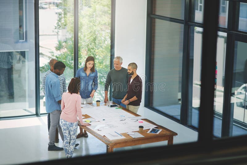Blueprints in the Boardroom. High Angle of a Group of Architects ...