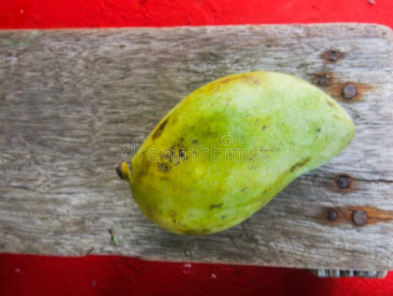 Blur Image of Unripped Maggo on Wooden Board Stock Photo - Image of ...