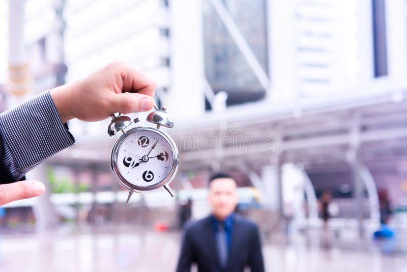 Blured Business Man is Standing Behind the Clock that Hold by an Stock ...