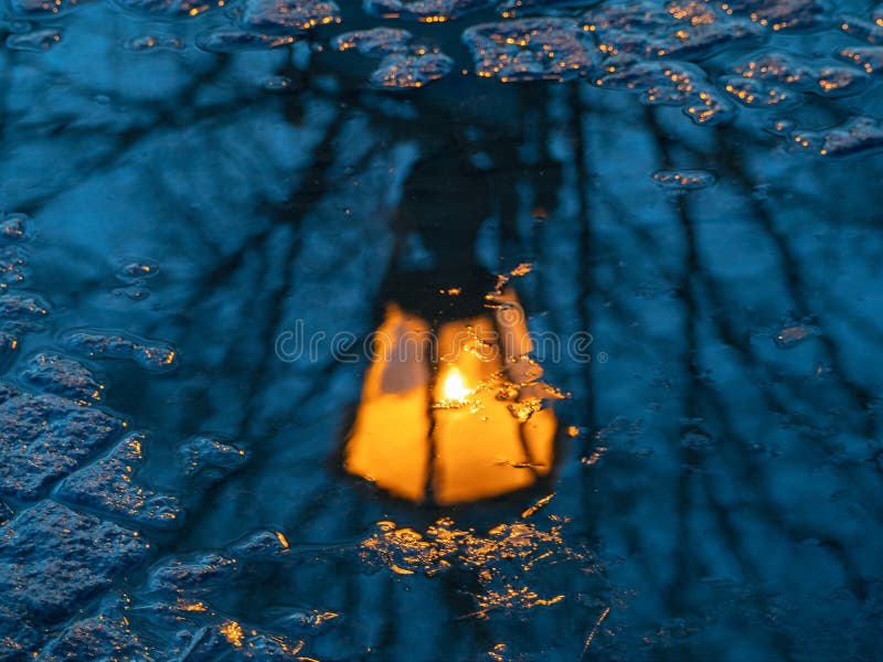 Blurred Antique Lantern Shines Yellow and is Reflected in a Spring ...