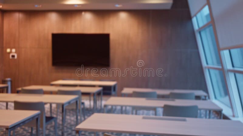 Blurred Classroom with Empty Desks and Chairs, Featuring a Large Screen ...