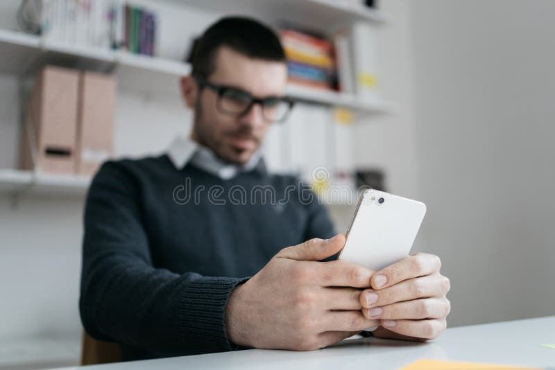 Blurred Man Holding on Focus Phone in Office Stock Photo - Image of ...