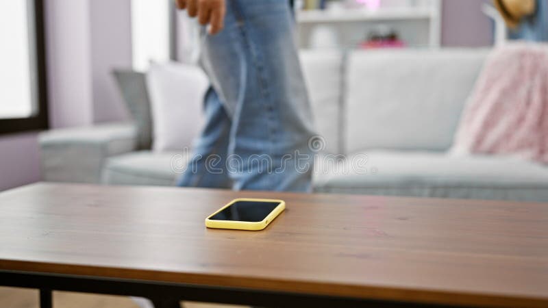 Blurred Young Man Walking Away from a Smartphone on a Table in a Modern ...