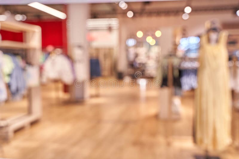 Blurry Clothing Store Interior with Racks and Lights Creating a Warm ...