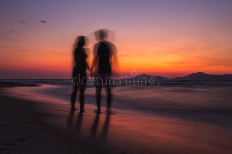 Blurry Couple on the Beach Watching Sunset Stock Photo - Image of blur ...