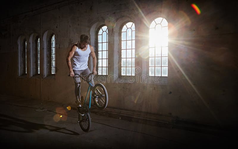 BMX Stunt and Jump Riding in a Hall with Sunlight. Stock Photo - Image ...