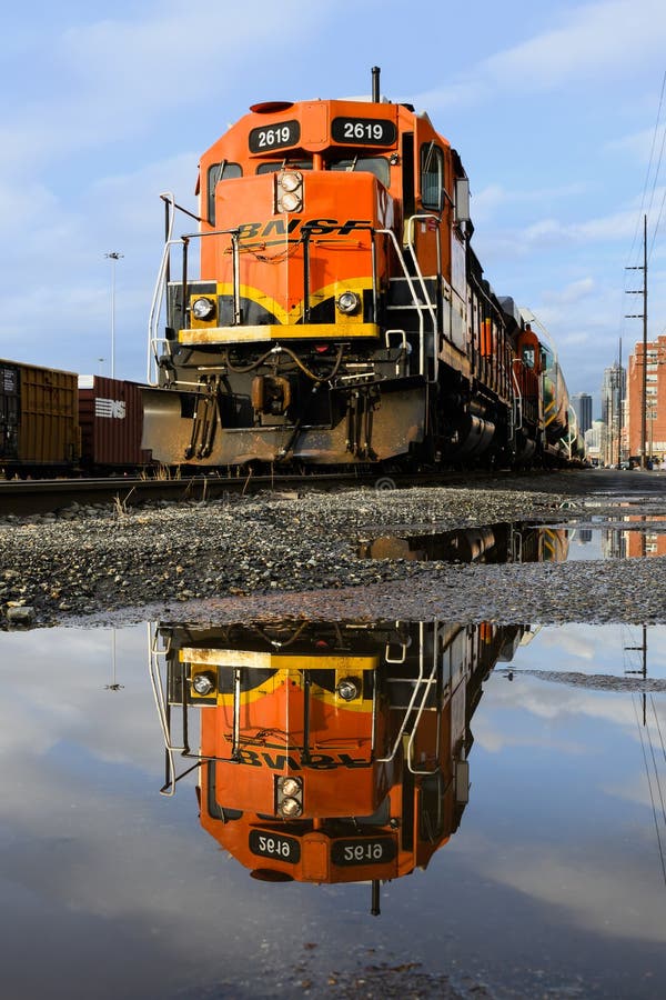 BNSF Freight Train Reflecting in Puddle in Sunshine Editorial ...