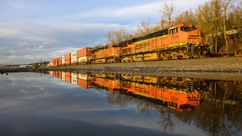 BNSF Intermodal Container Feight Train Reflecting in Puddle in Golden ...