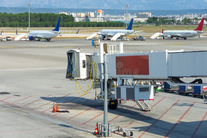 Boarding Bridge at the Airport Terminal and a Standing Plane in the ...